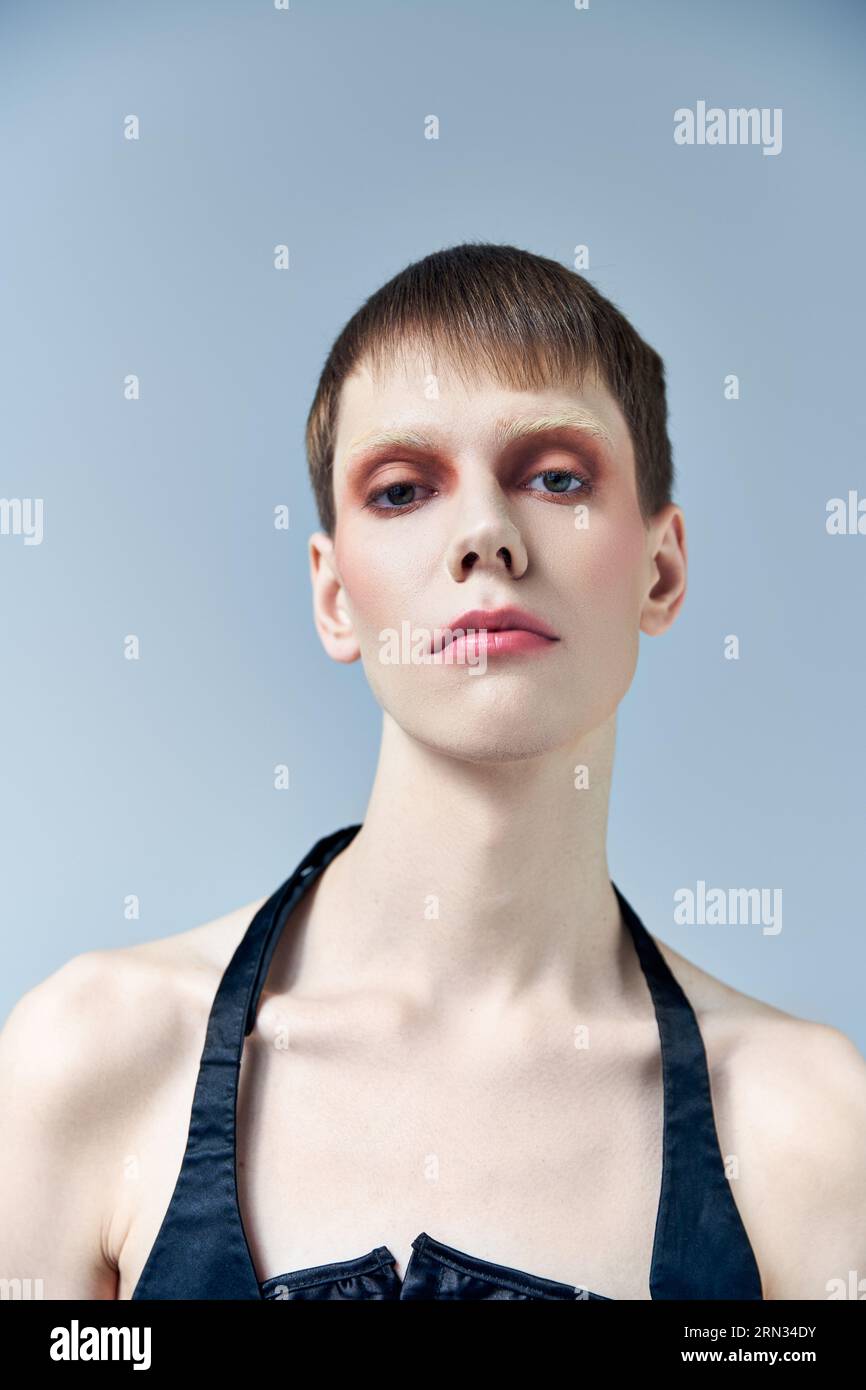 portrait, androgynous person with makeup, grey backdrop, beauty and ...