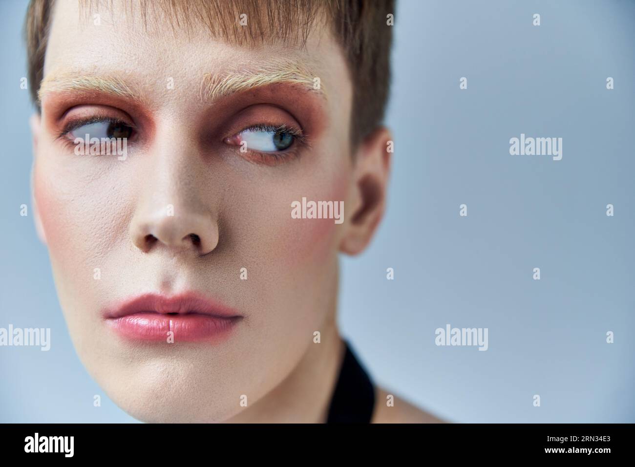 close up, androgynous person with makeup, grey backdrop, beauty and ...