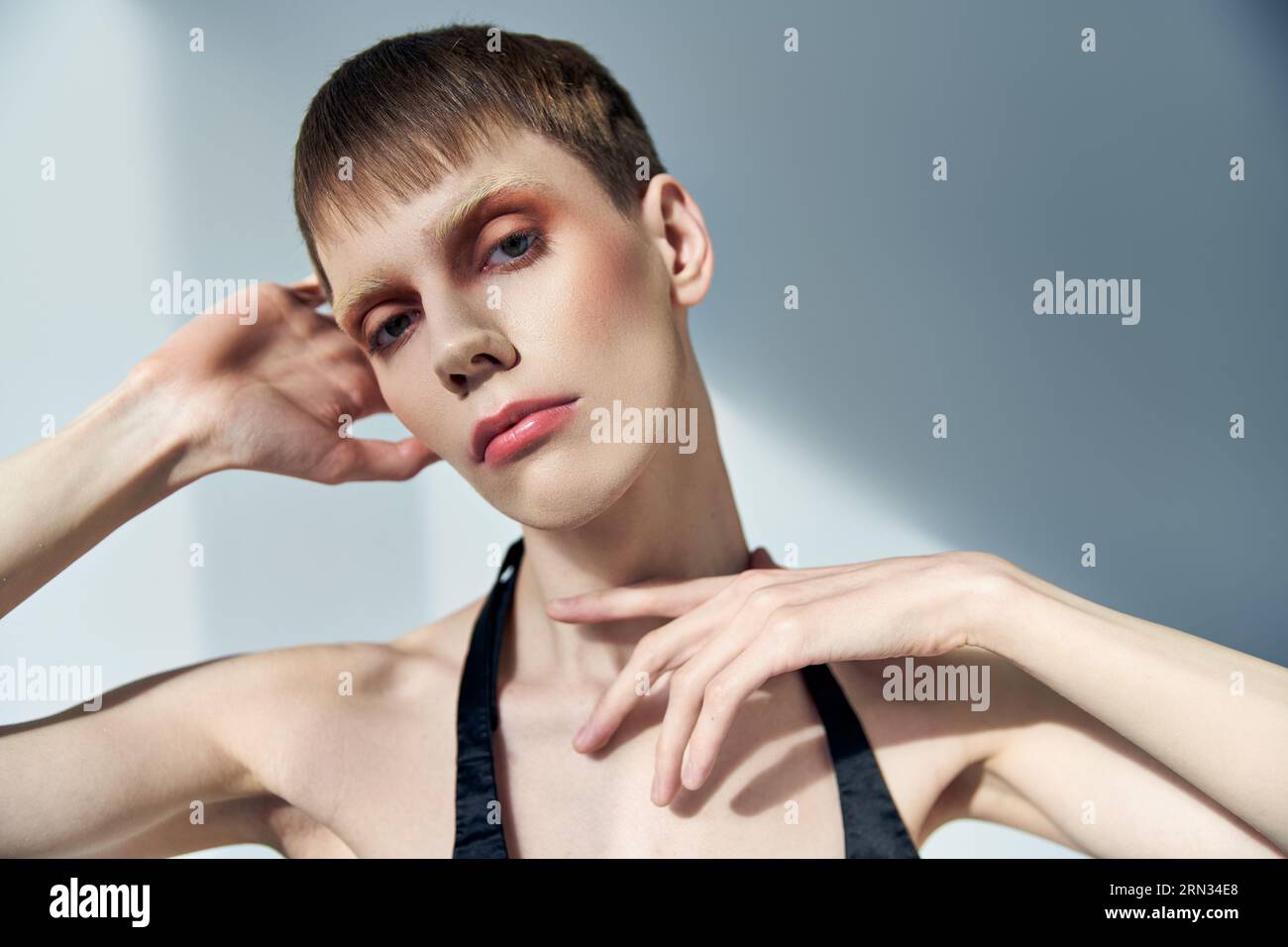 queer person with makeup posing on grey backdrop, beauty, visage ...