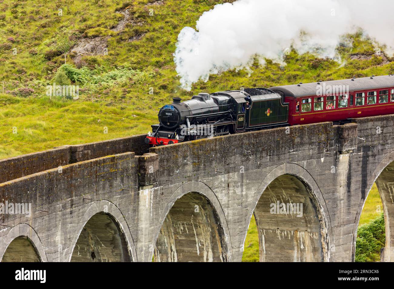 Famous steam training passing over a curved viaduct at Glenfinnan in ...
