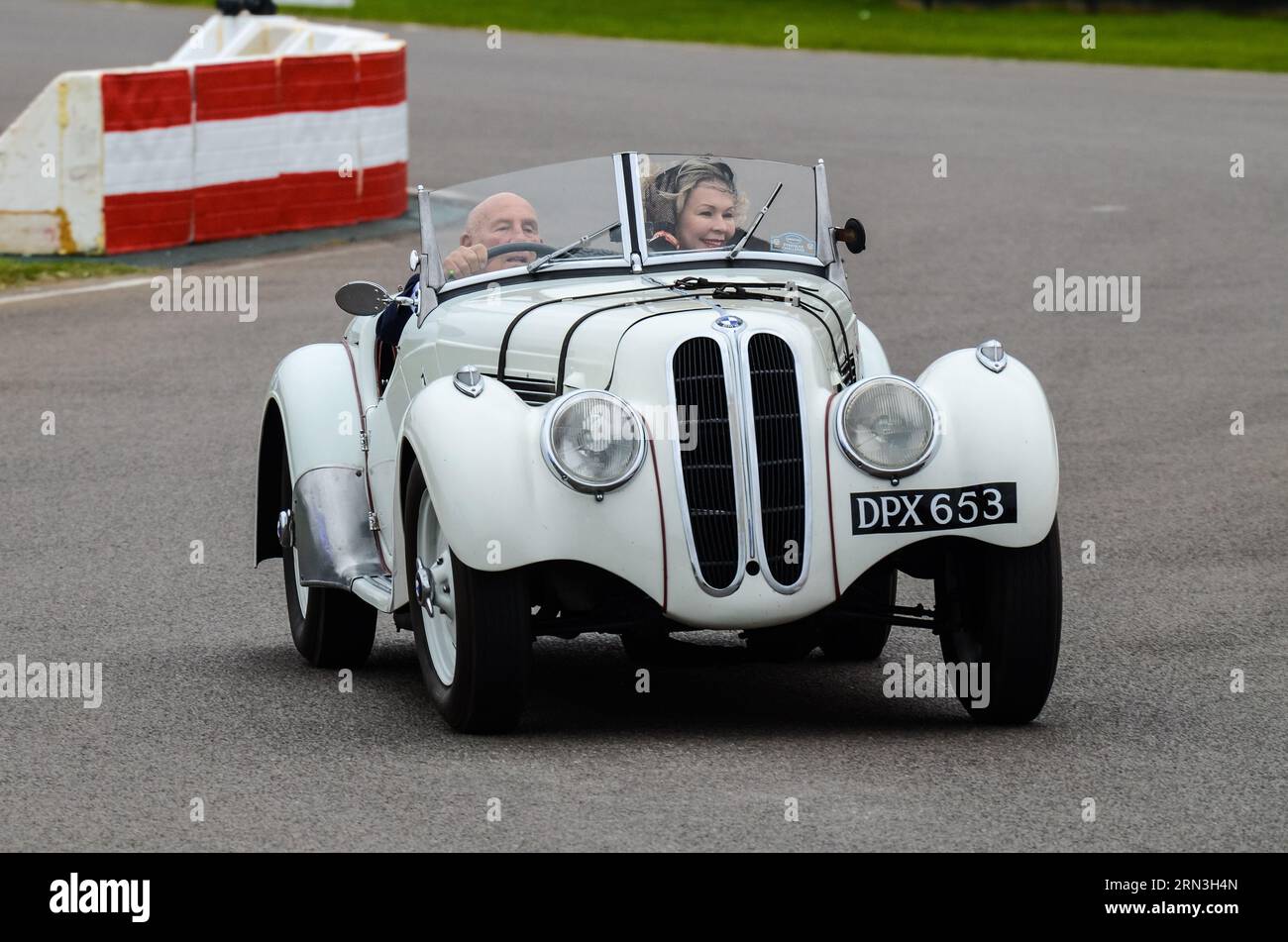 Sir Stirling Moss driving a vintage BMW 328 car on the track at the ...