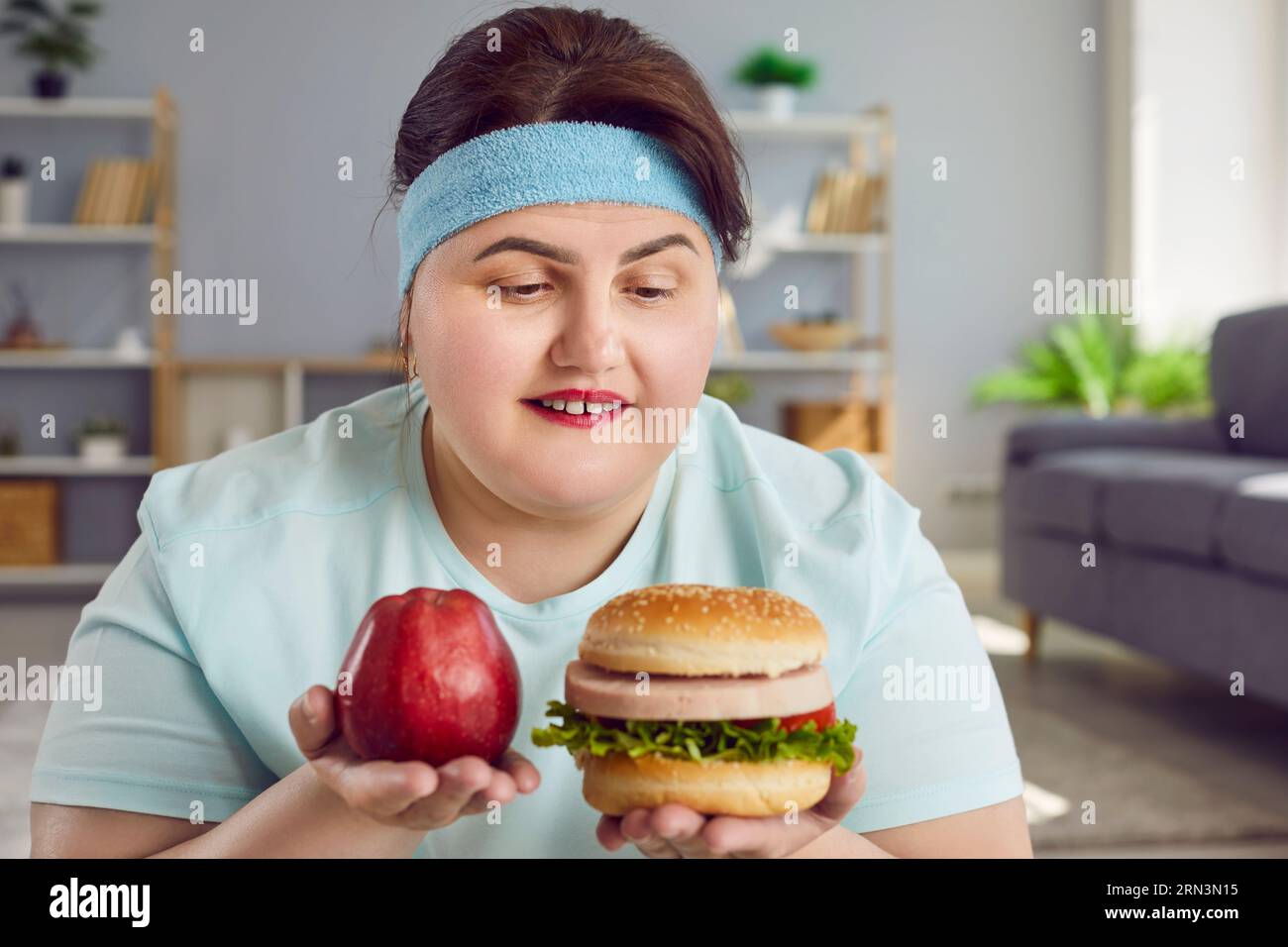 Funny fat woman looking at apple and hamburger and choosing between ...