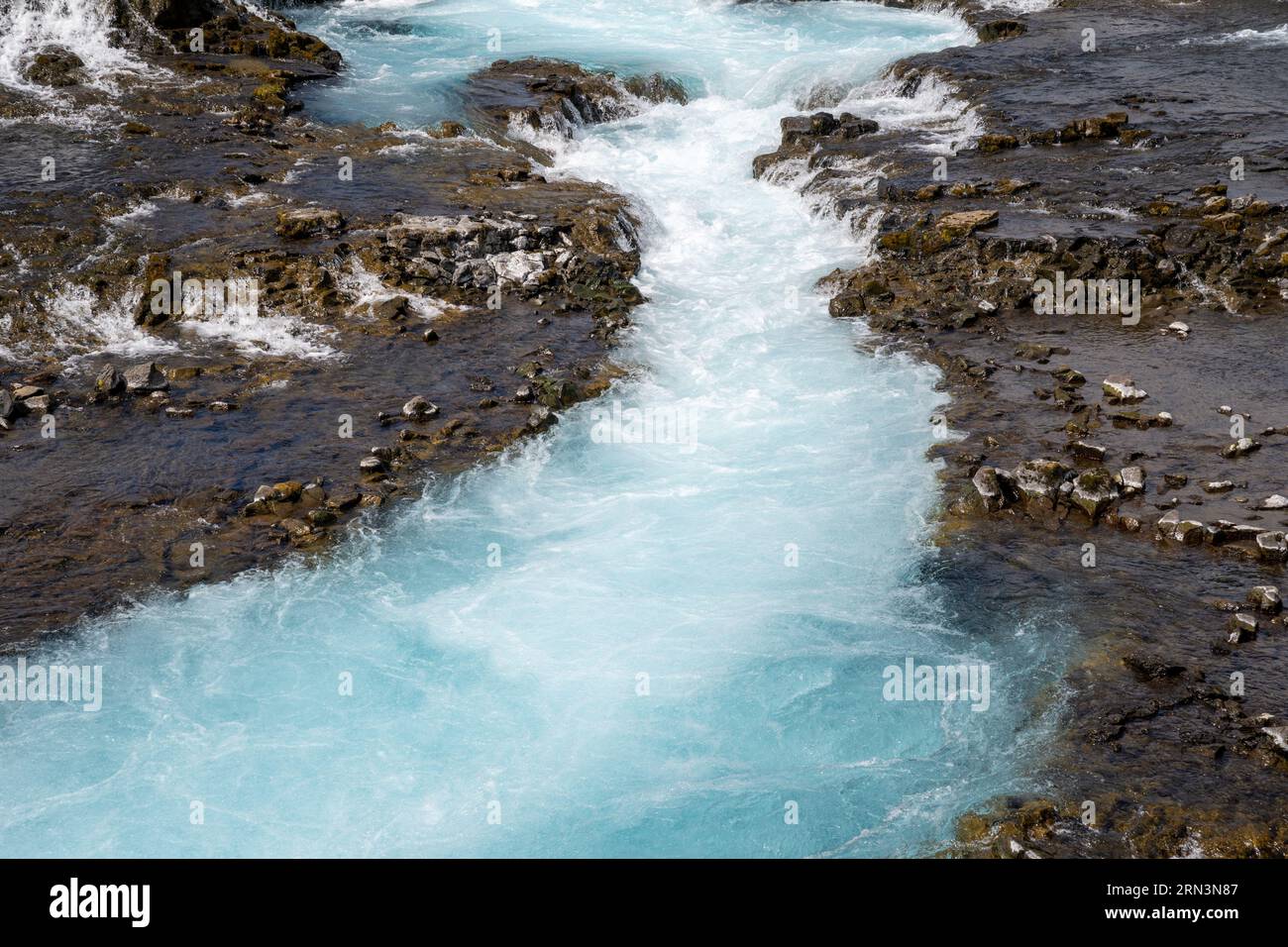 Bruarfoss waterfall on a sunny day in summer. Features beautiful teal ...
