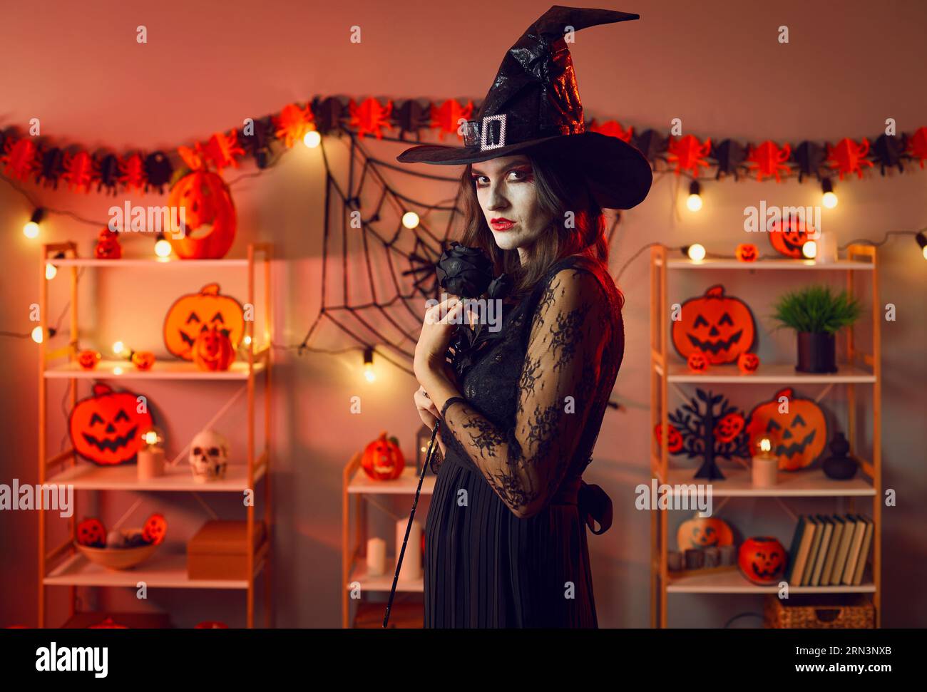 Portrait of mysterious and serious woman witch in room with Halloween ...