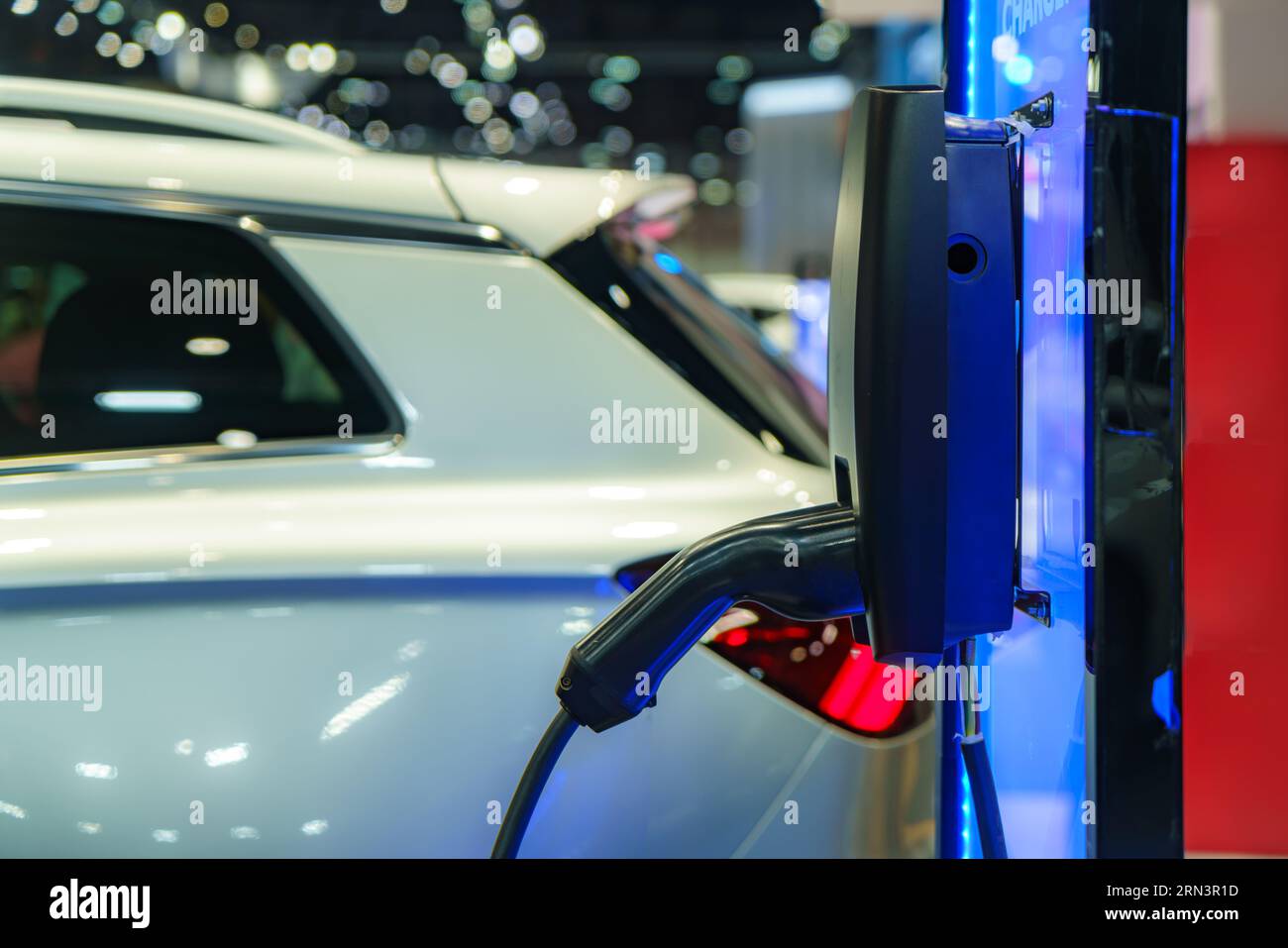 EV car rests at a charging station, power cable connected, embodying ...