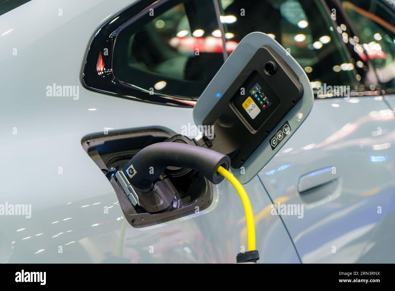 EV car rests at a charging station, power cable connected, embodying ...