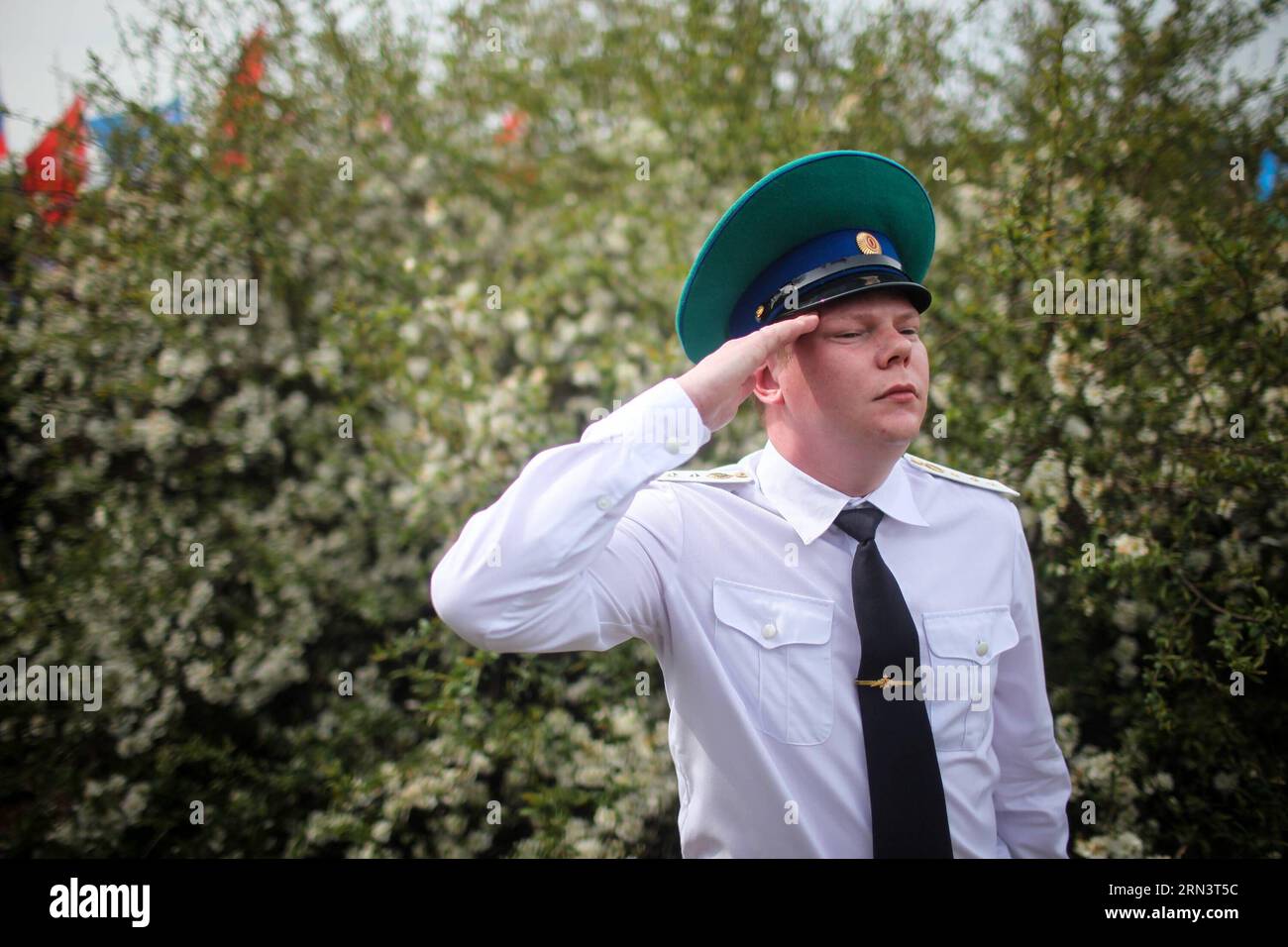 A man wearing military uniform salutes during celebrations of the 70th ...