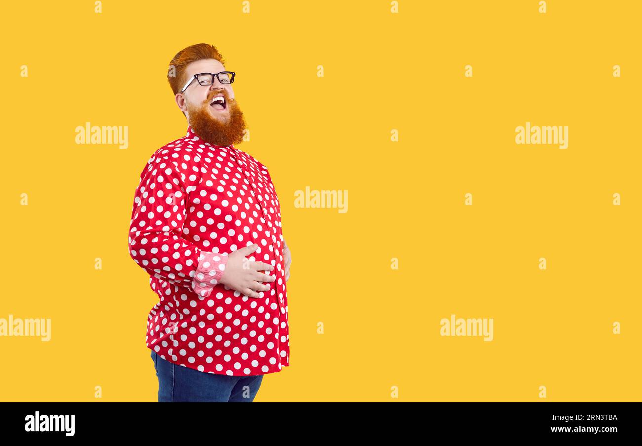 Funny happy fat man in polka dot shirt and glasses laughing on yellow ...