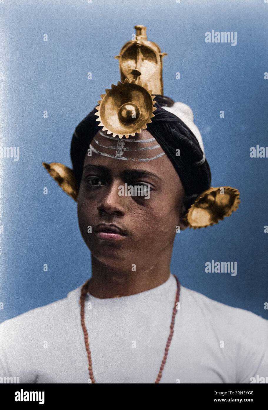 A young Indian man, wearing an elaborate headress and makeup, in a ...