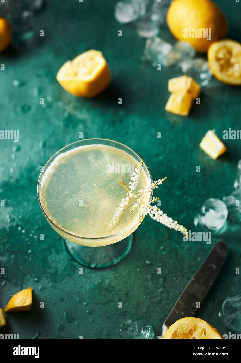 Refreshing cocktail on a teal background. Lots of lemons and ice ...