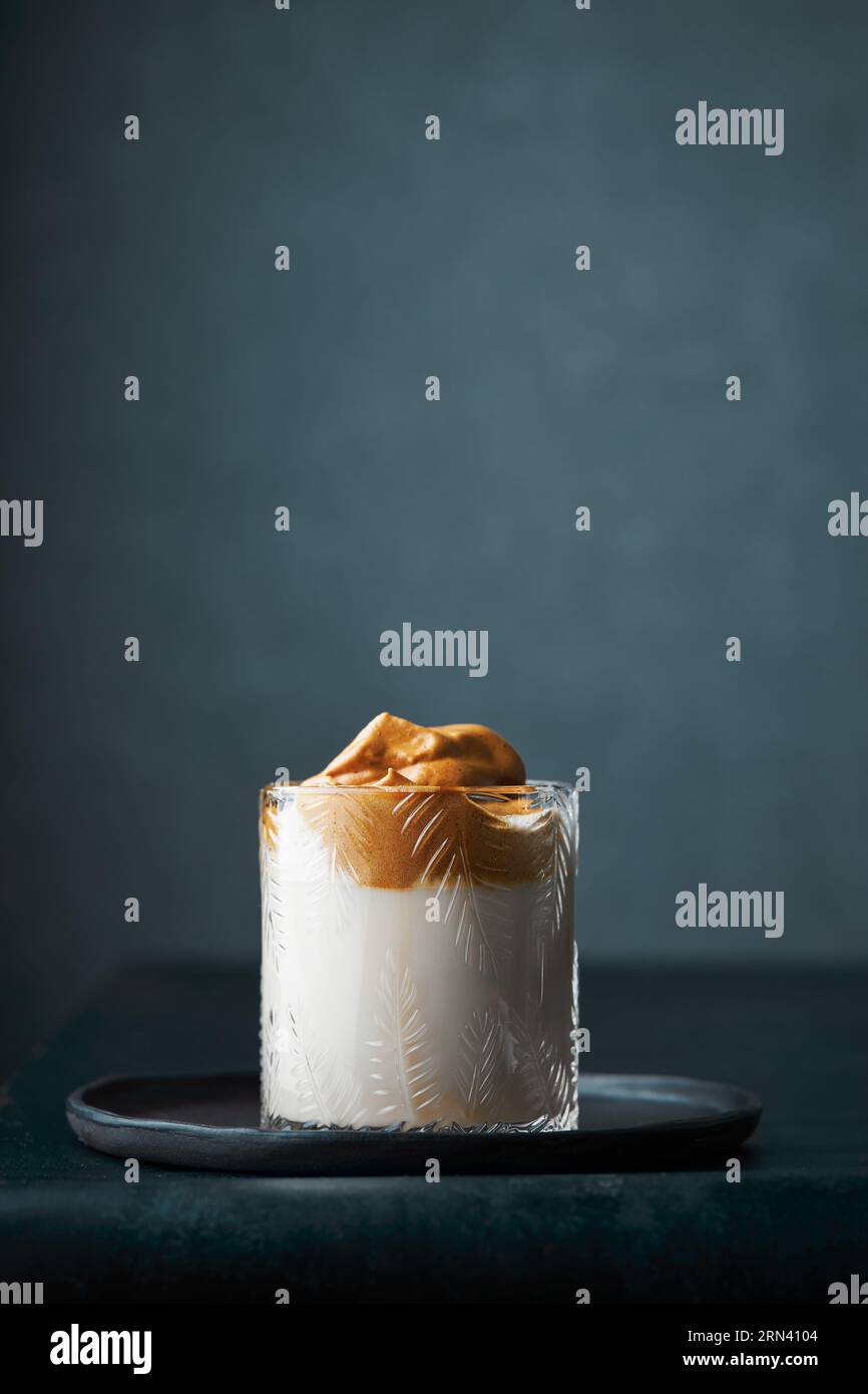 Dalgona coffee on a dark grey background and black color table. The ...