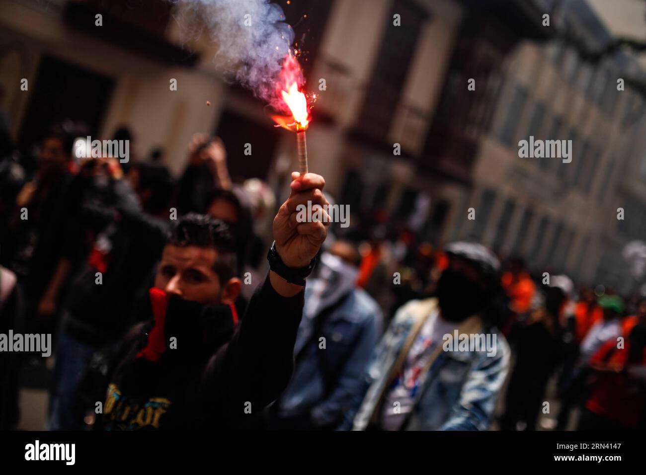 BOGOTA, May 1, 2015 -- A man holds a flare during a march in ...