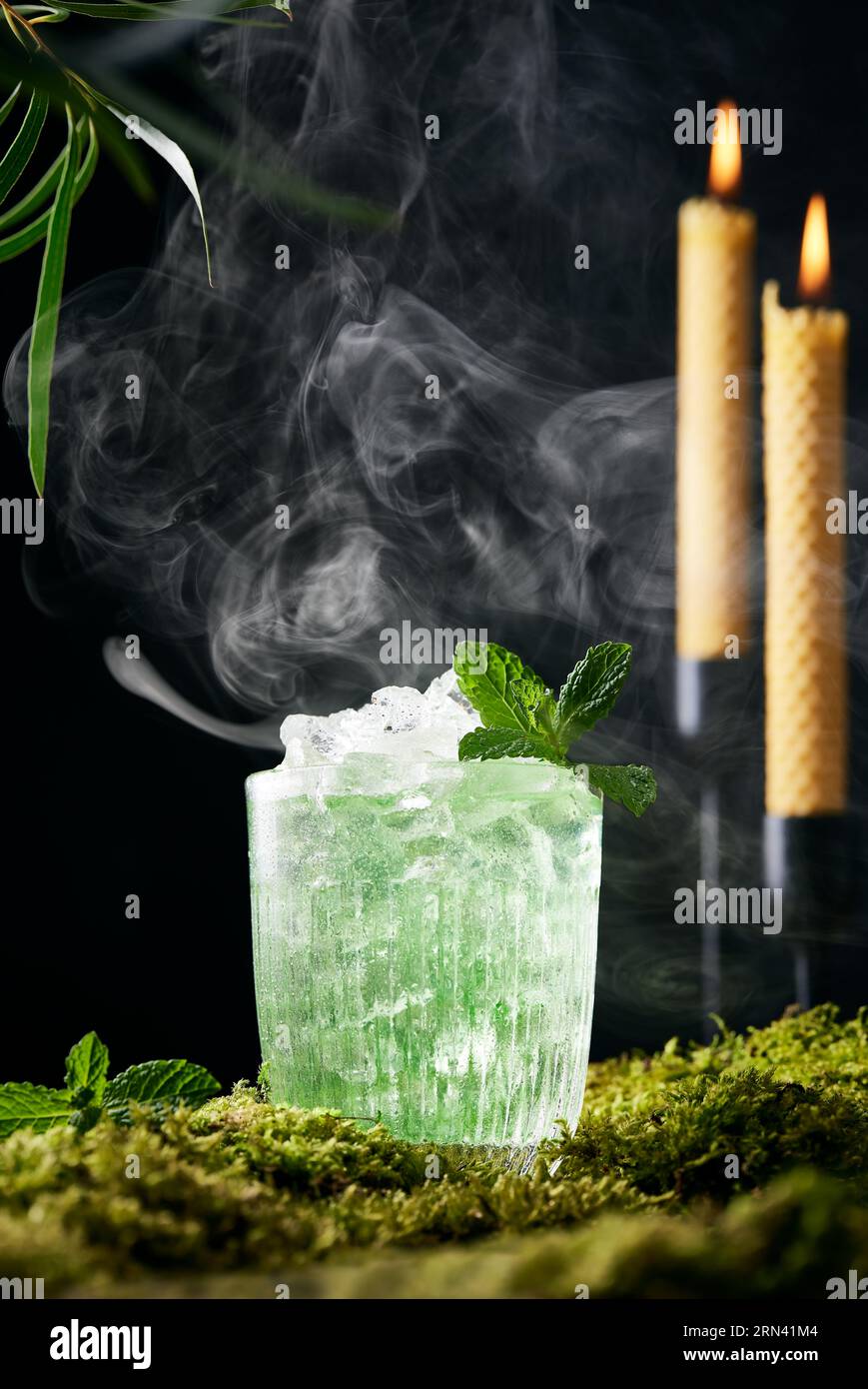 Light green cocktail with lots of ice, garnished with mint leave ...