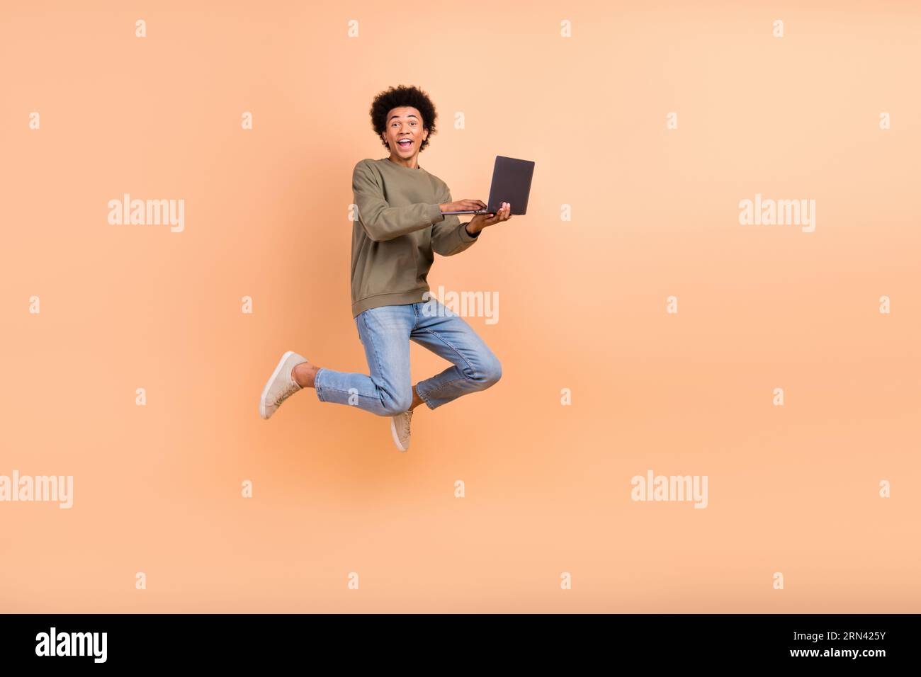 Full size portrait of crazy carefree person jump use wireless netbook ...