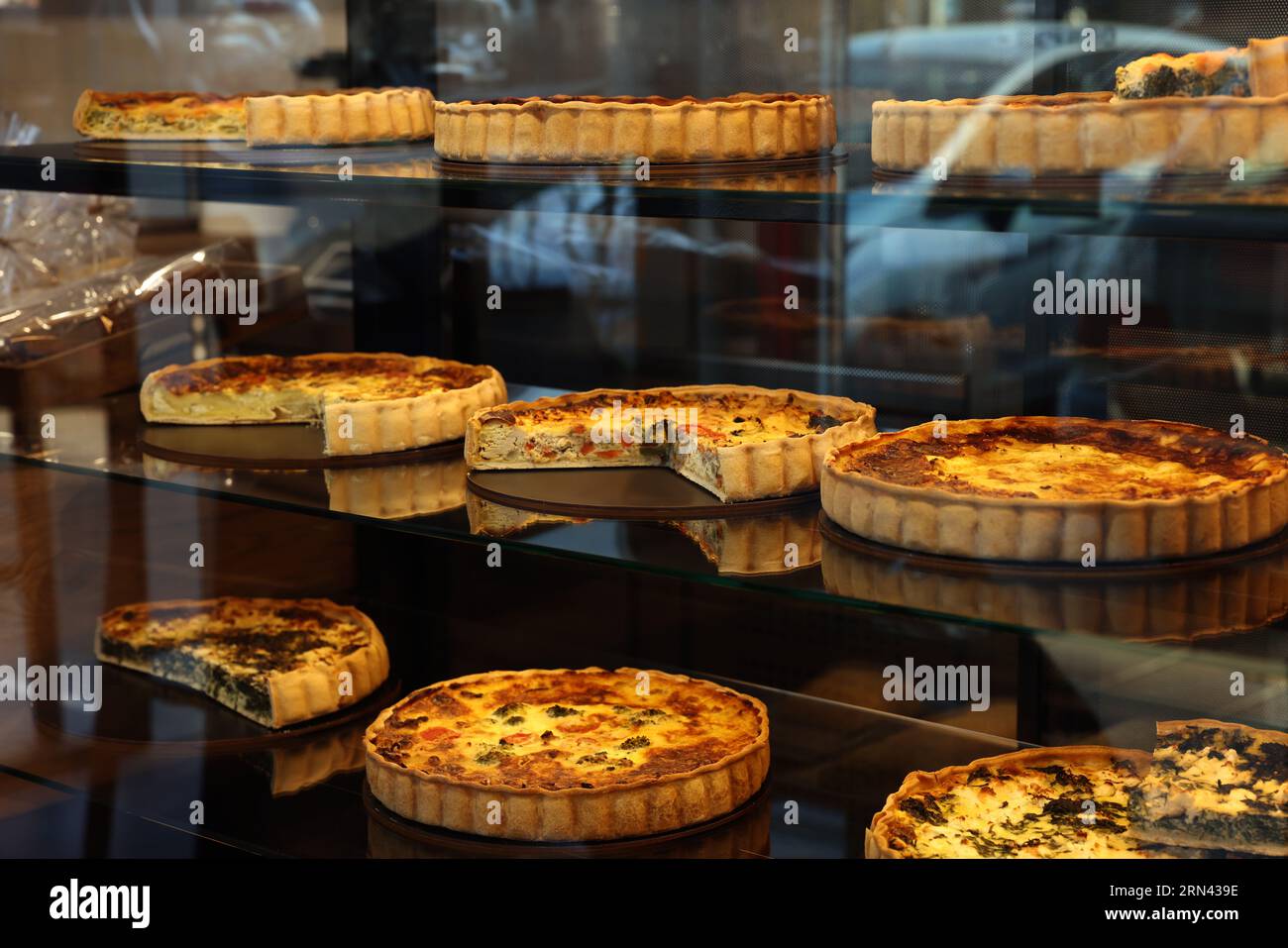 Different delicious quiches on counter in bakery shop Stock Photo - Alamy