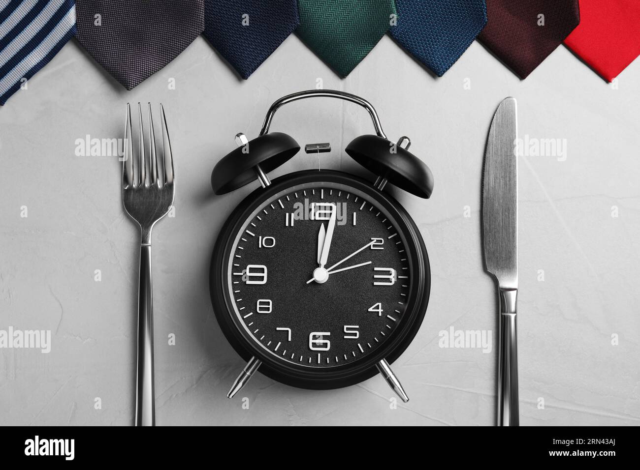 Business lunch concept. Alarm clock, cutlery and ties on light gray ...