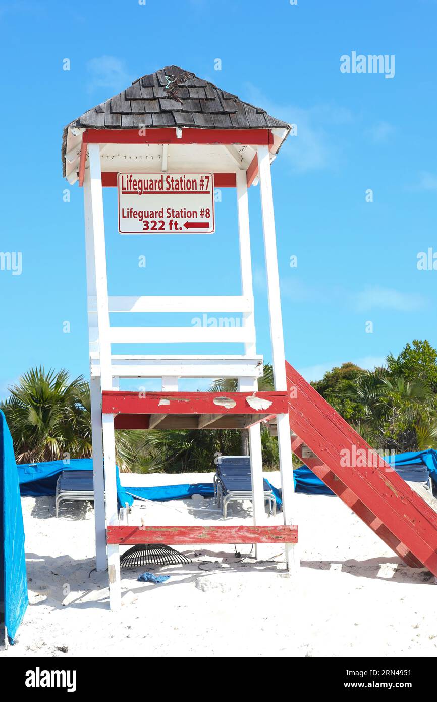 A white lifeguard stand with a red sign on the back that reads, No ...