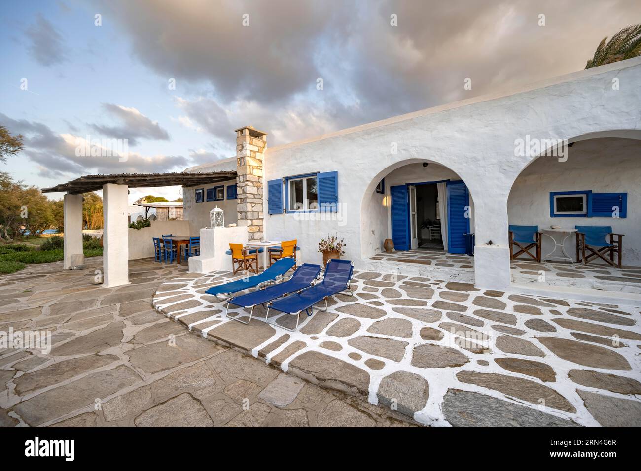 White Cycladic house with terrace with chairs and sun loungers, Holiday ...