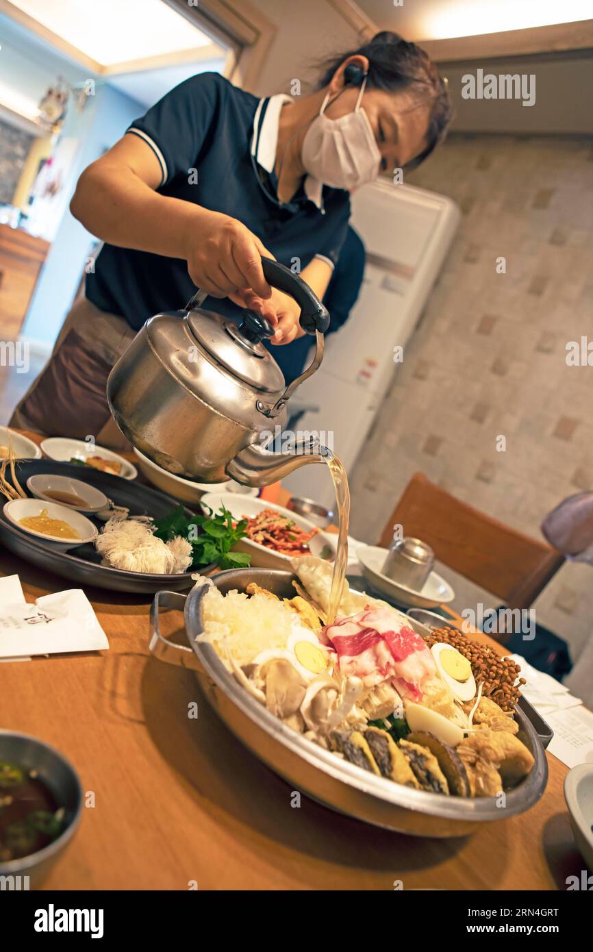 Korean woman pouring broth, Bok Jaeng Ban, traditional Korean dish ...