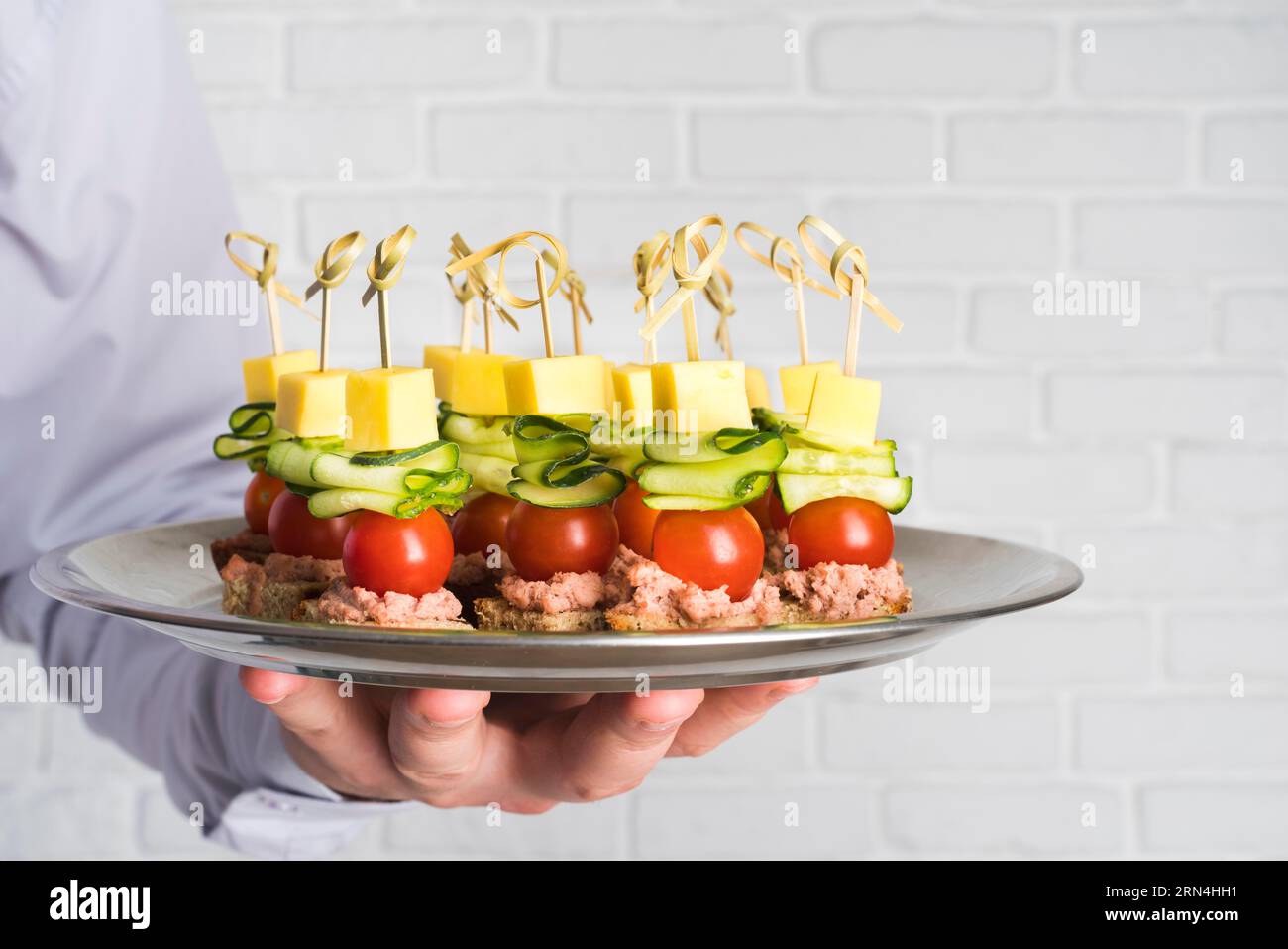 Chef holding plate with catering food Stock Photo - Alamy