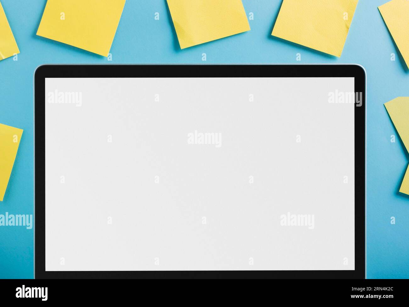 Laptop with blank white screen surrounded by yellow adhesive notes ...