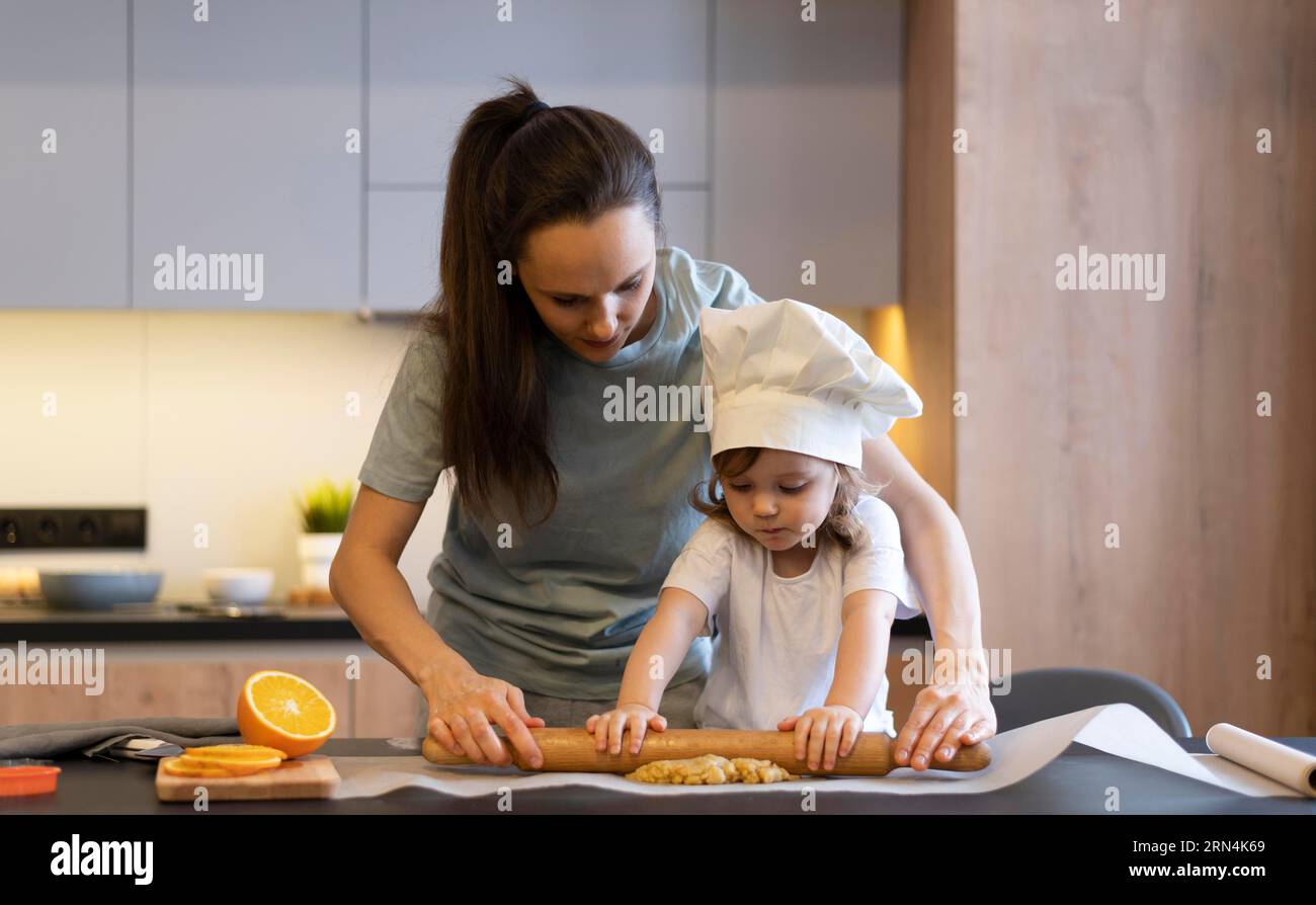 Medium shot mother kid using rolling pin Stock Photo - Alamy