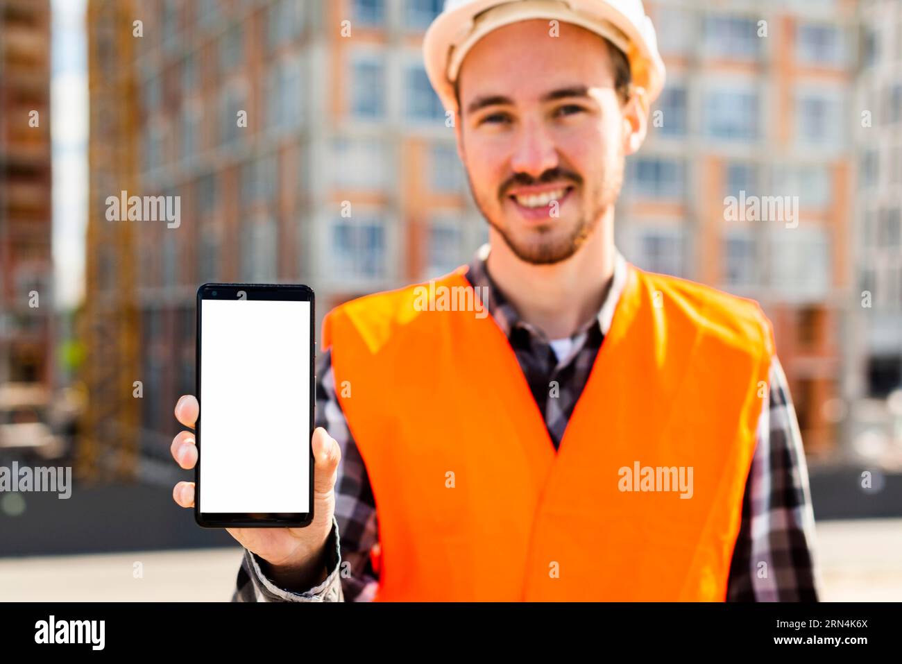 Medium shot portrait construction engineer holding phone Stock Photo ...