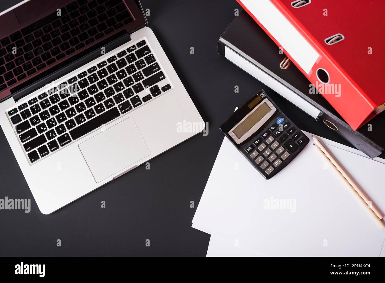Overhead view laptop file folders calculator pencils paper black ...