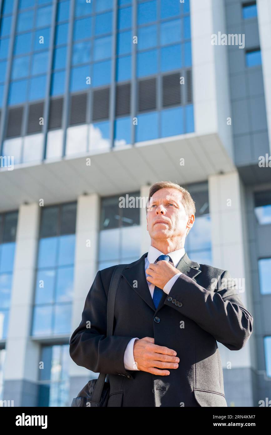 Professional mature man standing front building Stock Photo - Alamy