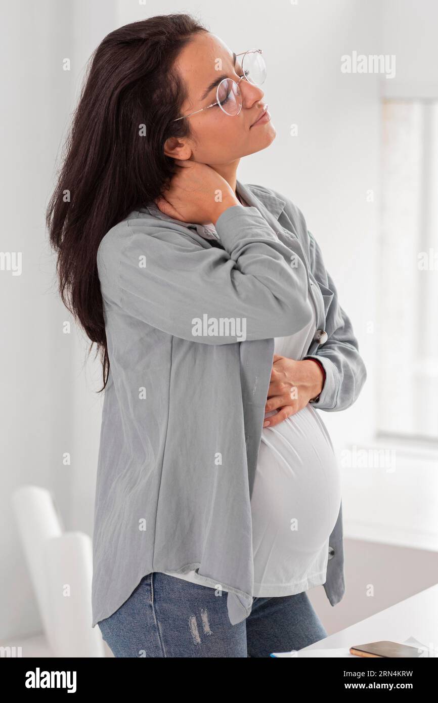 Side view pregnant woman holding her neck Stock Photo - Alamy