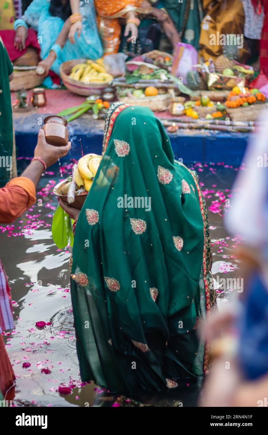 devotee praying with religious offerings for sun god in Chhath festival ...