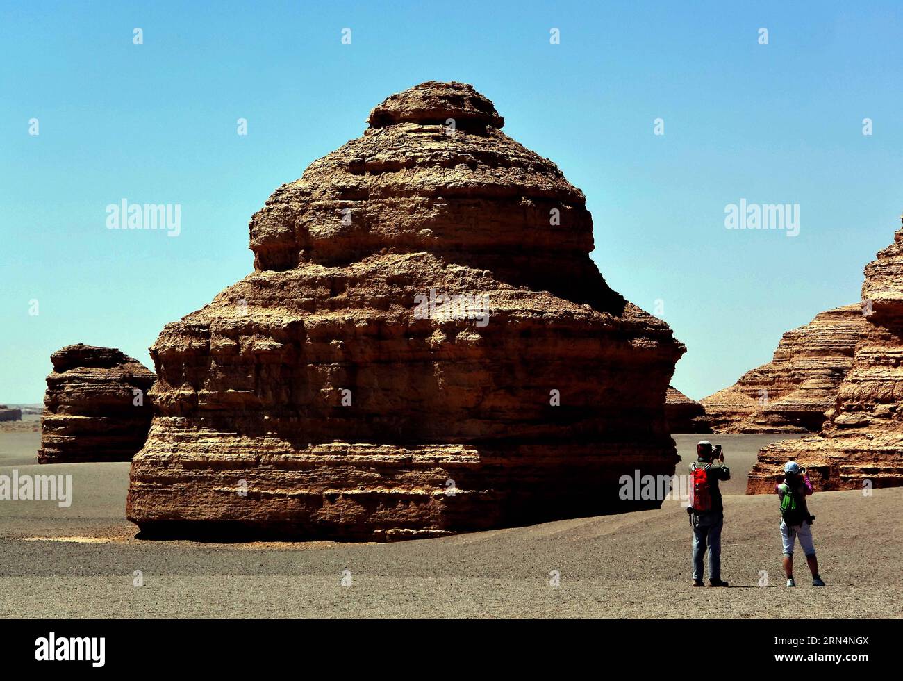DUNHUANG, May 24, 2015 -- Tourists take photos of yardang landforms at ...