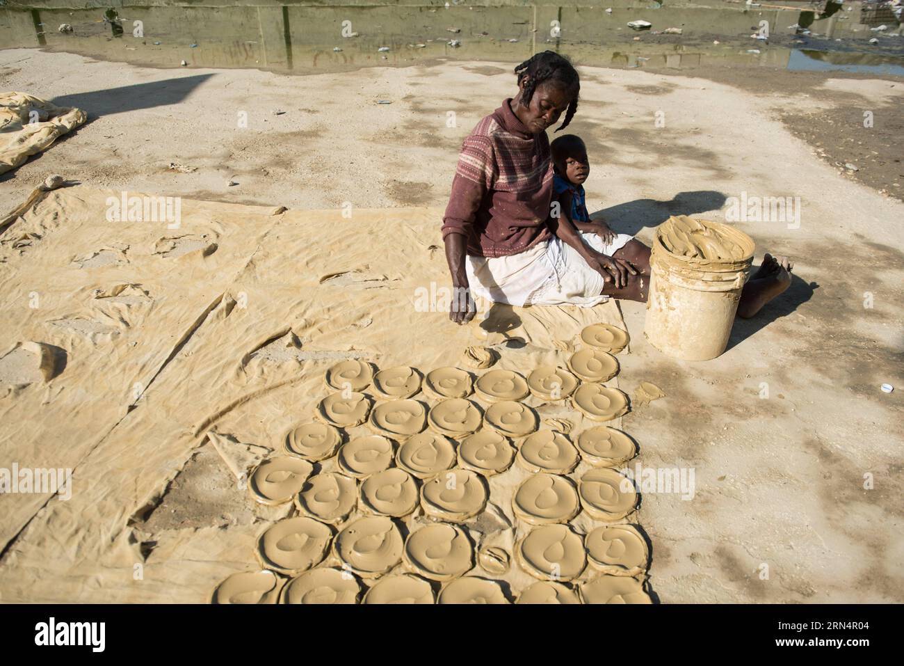 PORT AU PRINCE, May 27, 2015 -- A woman places mud cookies to sun ...