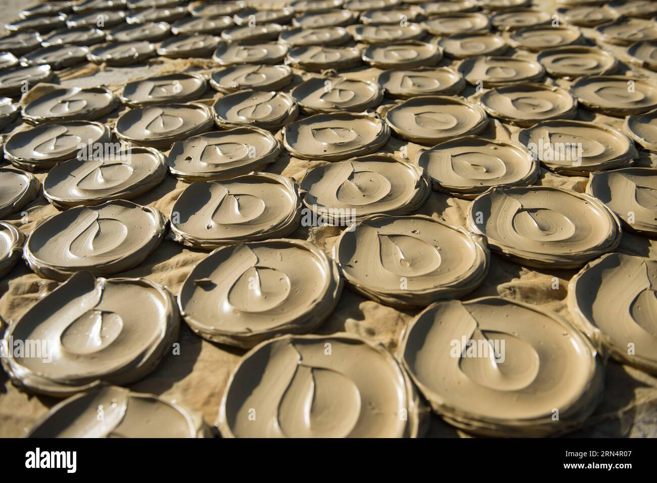 PORT AU PRINCE, May 27, 2015 -- Mud cookies are placed on the ground in ...
