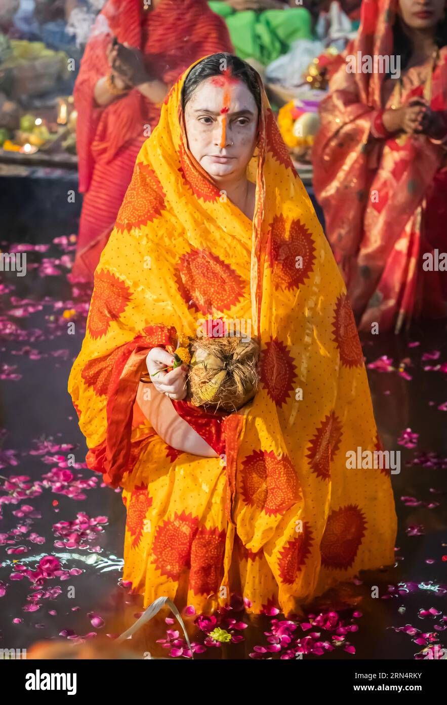 women devotee standing in river and praying with religious offerings ...