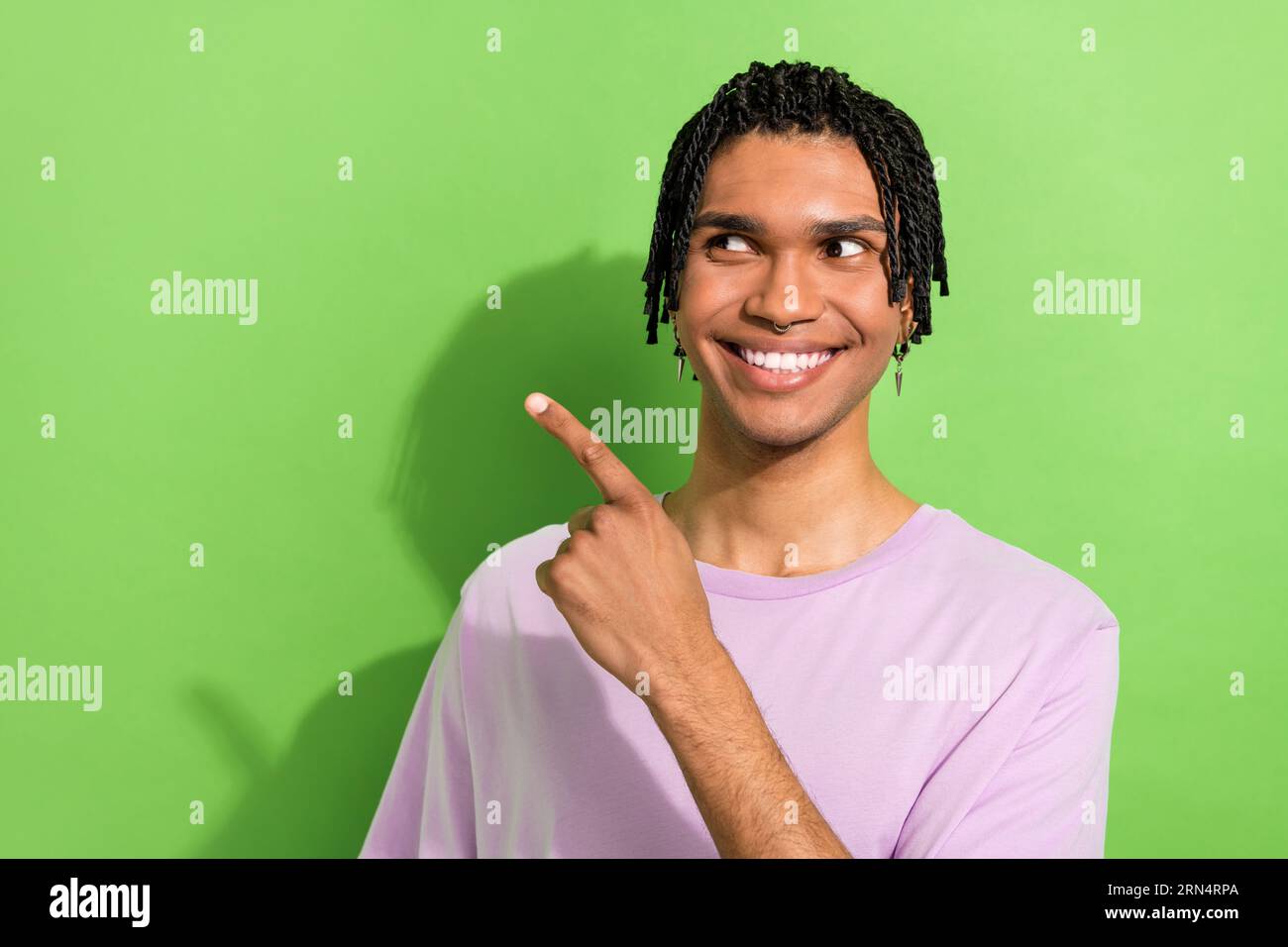 Photo of youngster guy wearing hair cornrows directing finger empty ...