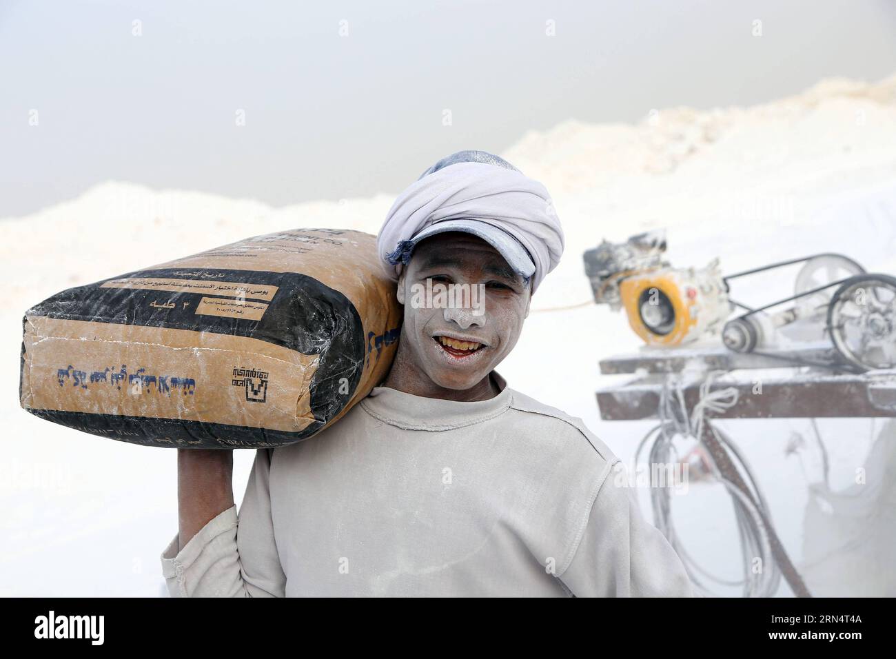 (150530) -- MINYA, - An Egyptian worker carrying packed cement poses on ...