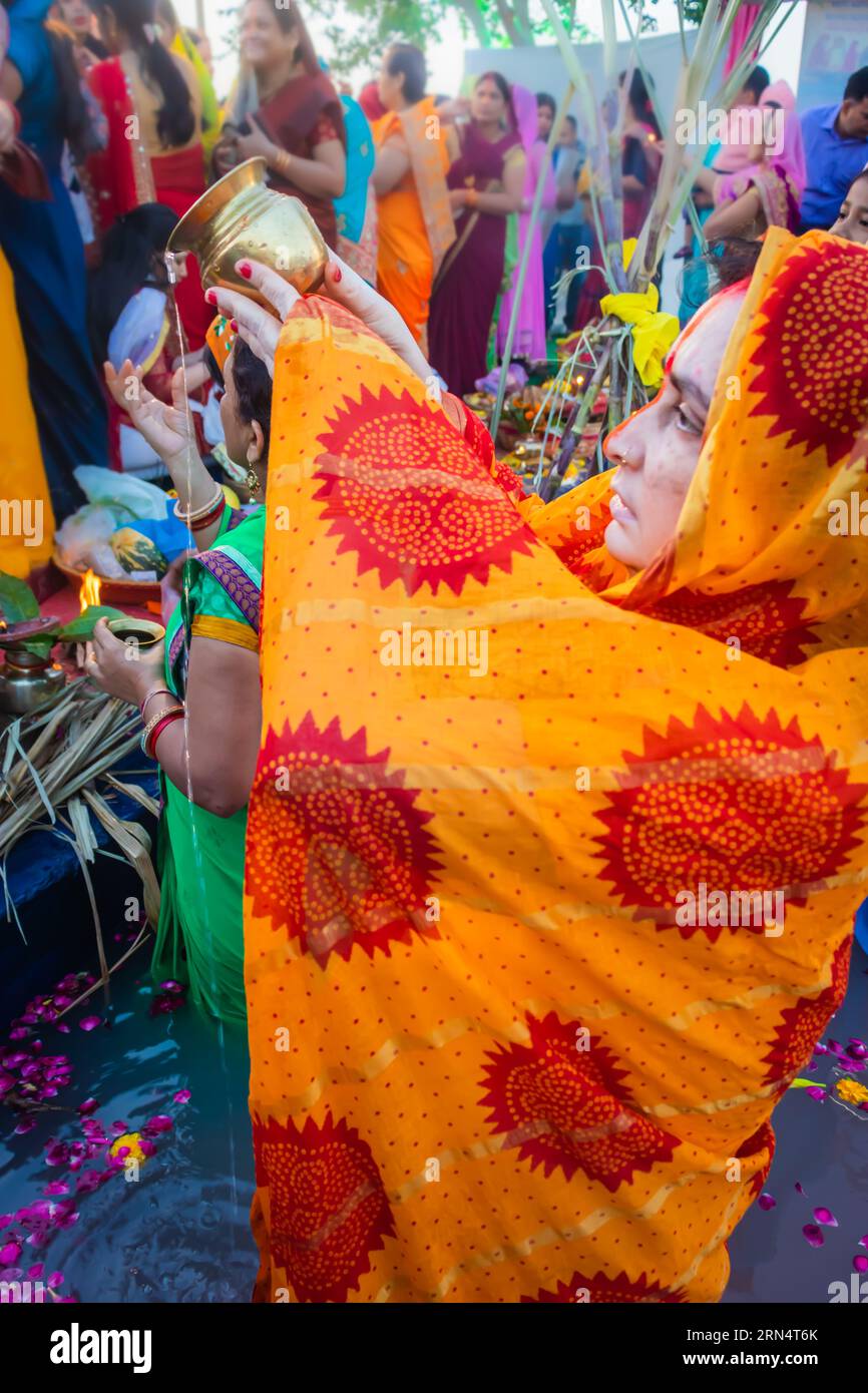 women devotee standing in river and praying with religious offerings ...