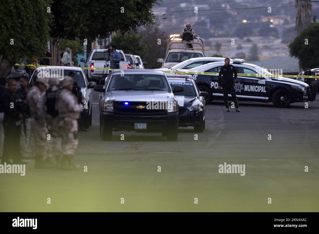 Policemen stand guard at the site where a police officer was killed ...