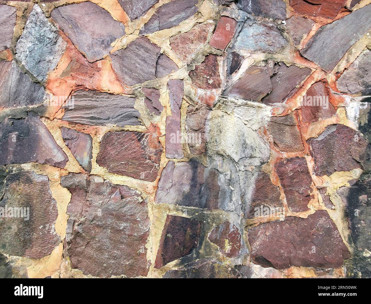 Wall consisting of irregularly shaped stones in different colours ...