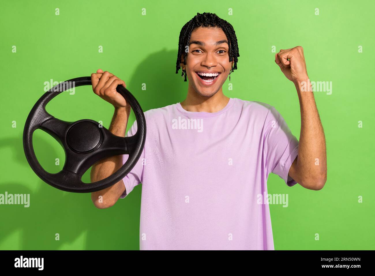 Portrait of handsome positive person arm hold wheel raise fist triumph ...