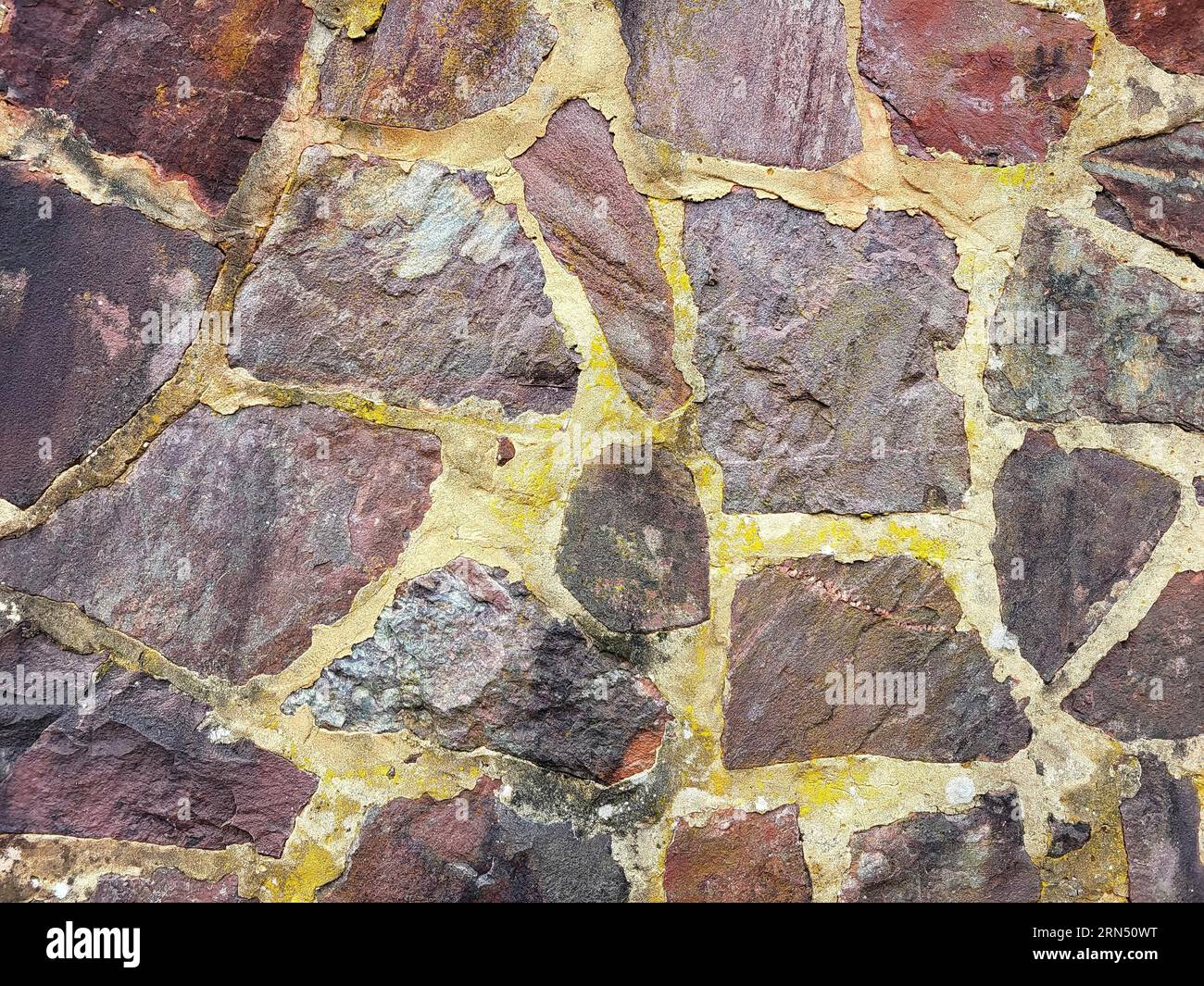 Wall consisting of irregularly shaped stones in different colours ...