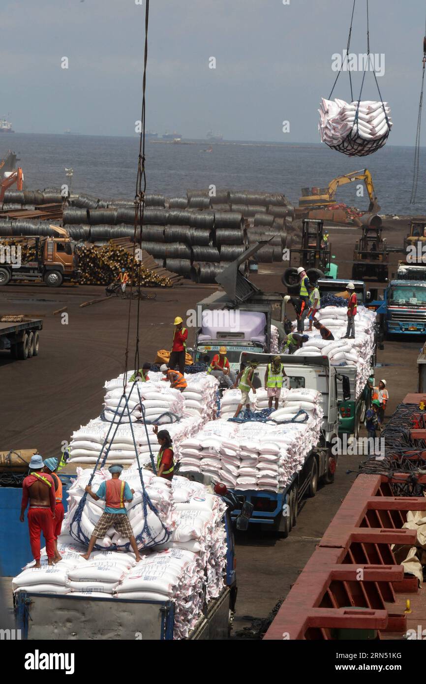 Workers unload sacks of imported rice from Vietnam at a port area in ...