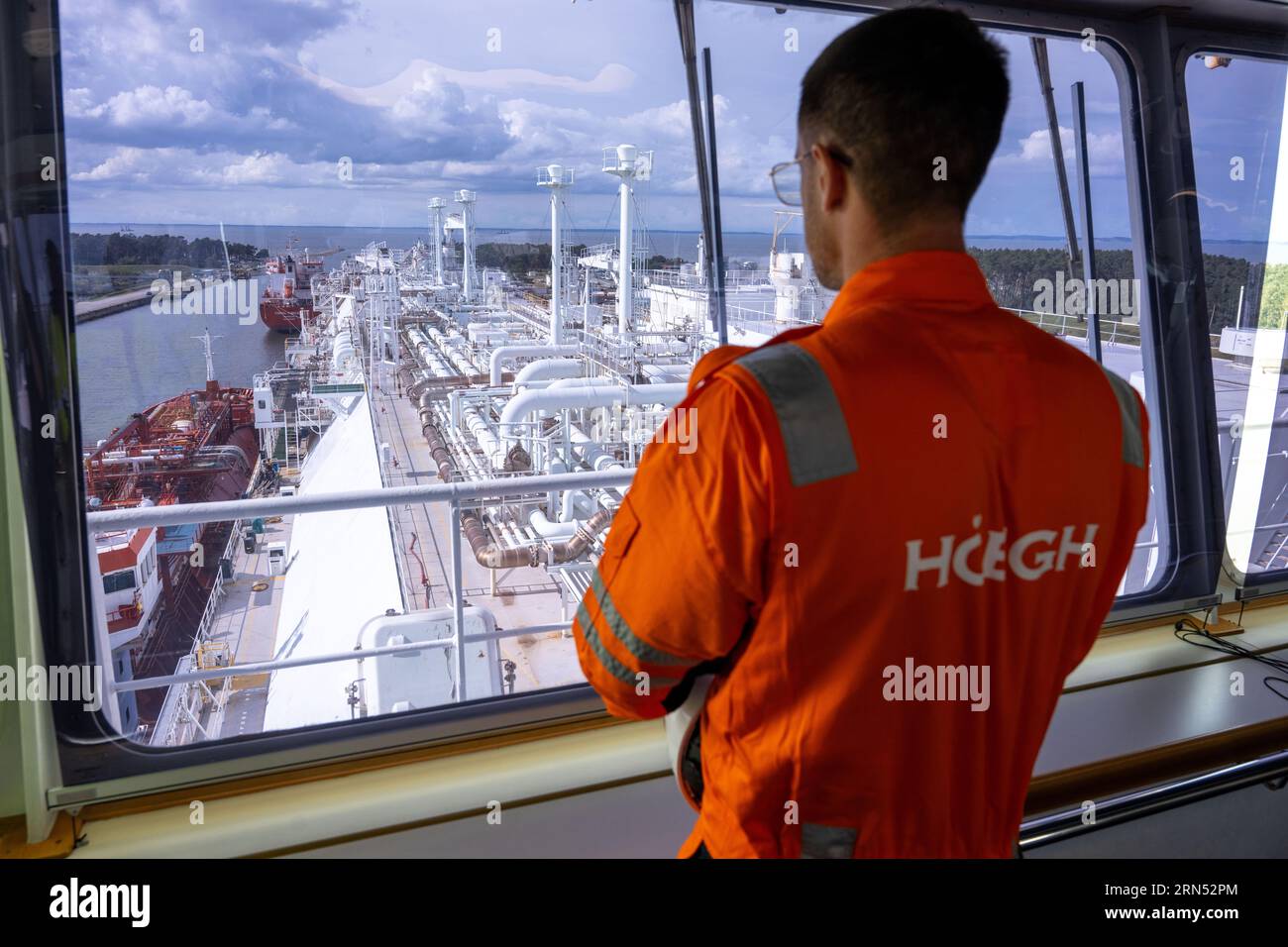 Lubmin, Germany. 31st Aug, 2023. An employee of Höegh LNG stands on the ...