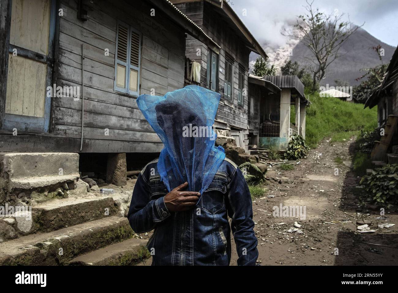 (150614) -- NORTH SUMATRA, June 14, 2015 -- A man covers his face with ...