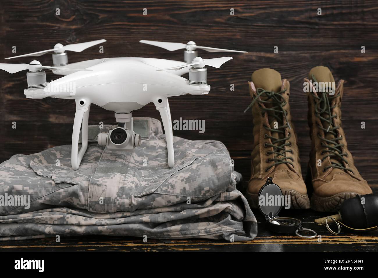 Modern quadcopter, military uniform, grenade and compass on wooden ...