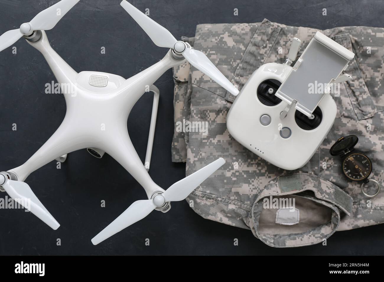 Modern quadcopter, military uniform, remote control and compass on ...