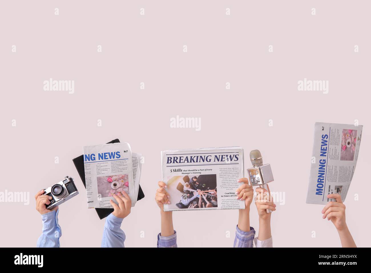 Female hands with different newspapers, microphone and photo camera on ...