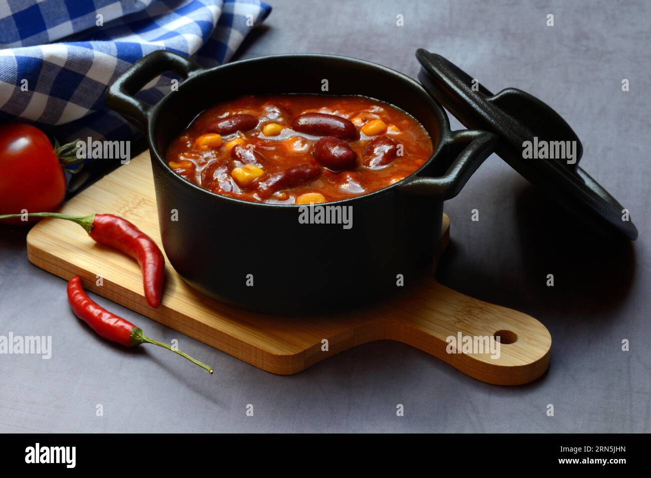 Chilli con carne, bean stew in pots and chilli peppers Stock Photo - Alamy