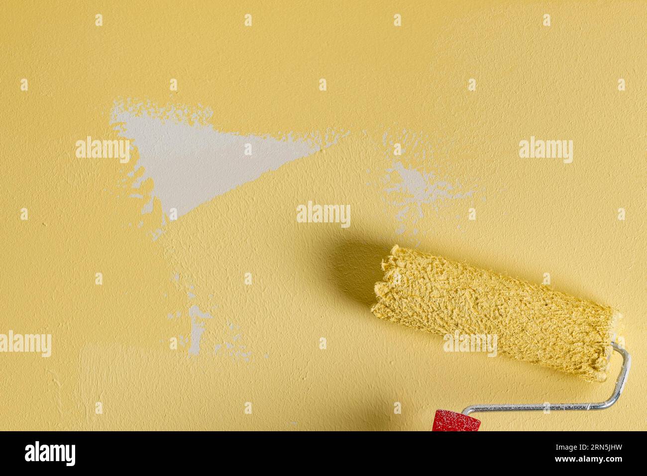 Unfinished painted wall with paint roller Stock Photo - Alamy